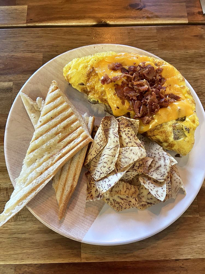 This isn't just breakfast; it's edible architecture. The omelet stands proud while toast and potatoes play supporting roles in this morning masterpiece.