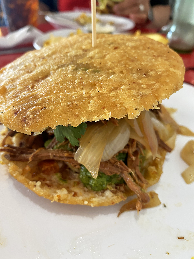 Behold the star of the show&mdash;shredded perfection nestled between golden cornmeal patties. This arepa doesn't just satisfy hunger; it creates food memories that haunt you.