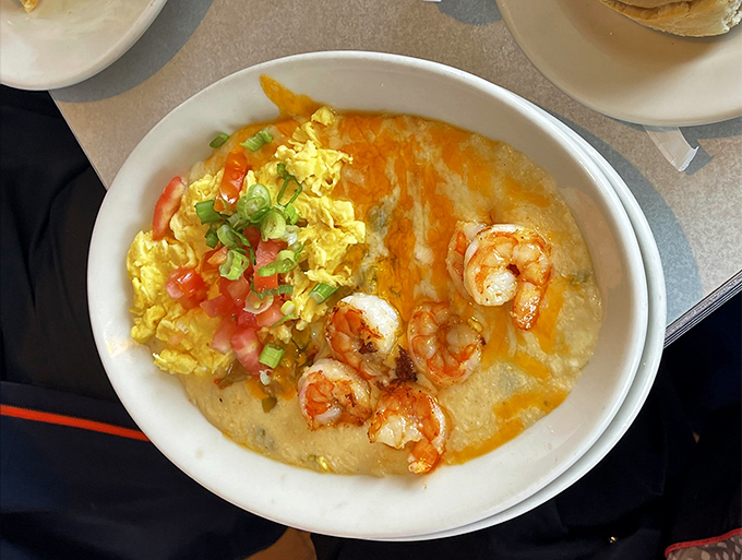 Behold the star attraction: shrimp and grits elevated to art form, where plump shrimp and creamy grits mingle with eggs and fresh vegetables in perfect harmony.