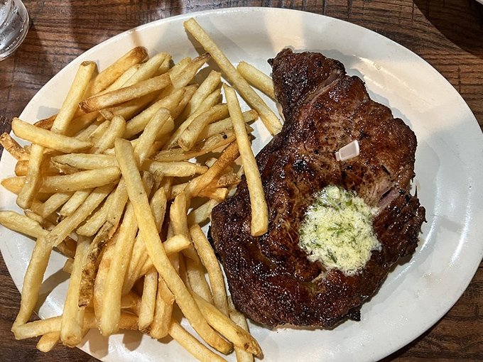 A perfectly seared steak with a pat of herb butter slowly melting into meat so tender it practically cuts itself.