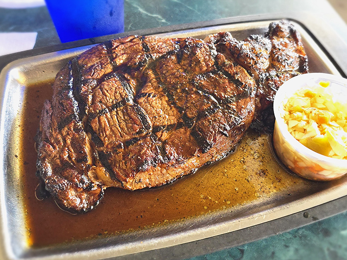 Behold the steak that launched a thousand road trips! Perfectly seared, juicy, and taking up real estate on a metal tray like it owns the place.
