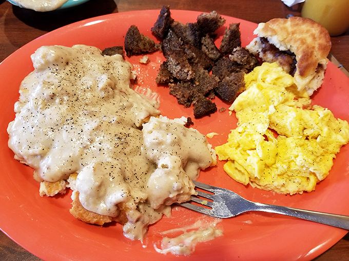 Behold the holy trinity of breakfast: creamy gravy-smothered biscuits, scrambled eggs, and country ham that would make your cardiologist wince and your taste buds sing.
