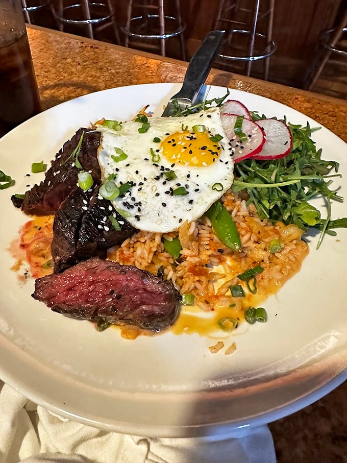 Steak and eggs reimagined as art. That sunny-side up masterpiece perched atop perfectly seared beef is the breakfast equivalent of winning the lottery.