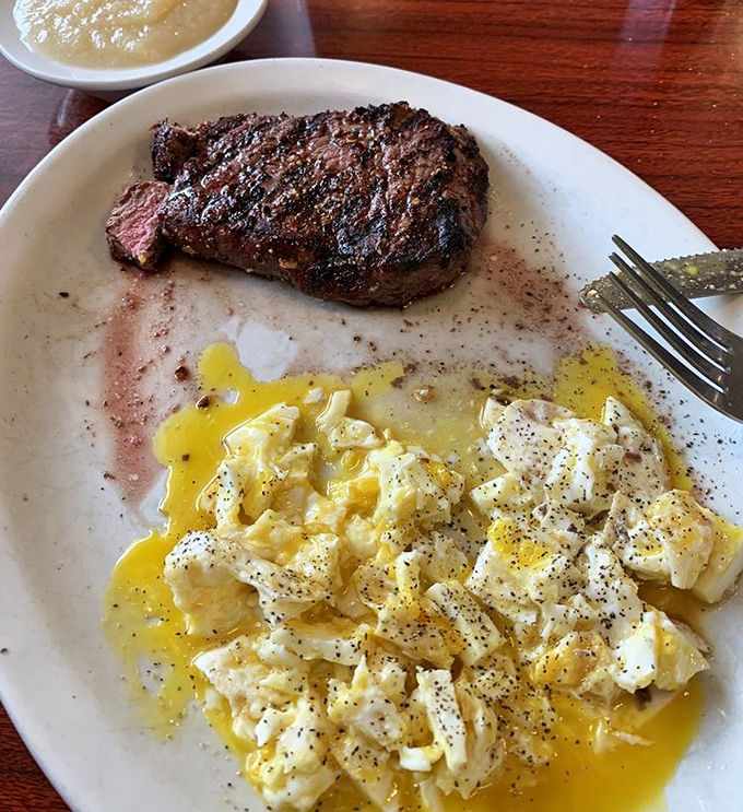 Behold the star attraction: a perfectly seasoned steak alongside fluffy scrambled eggs. This plate doesn't just satisfy hunger &ndash; it creates food memories that linger for days.