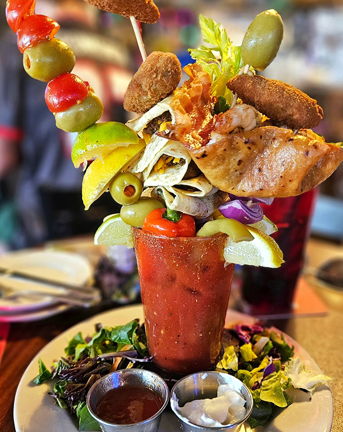 This isn't just a Bloody Mary&mdash;it's an architectural achievement. Olives, celery, and various fried goodies create a skyscraper of savory delights worth every precarious bite.