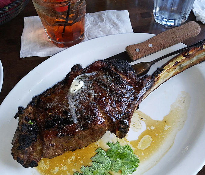 The tomahawk ribeye arrives like a prehistoric masterpiece that Fred Flintstone would applaud.