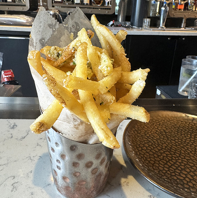 These aren't just fries&mdash;they're a golden treasure chest of crispy potato perfection. Served in a metal cup because paper would simply be undignified.