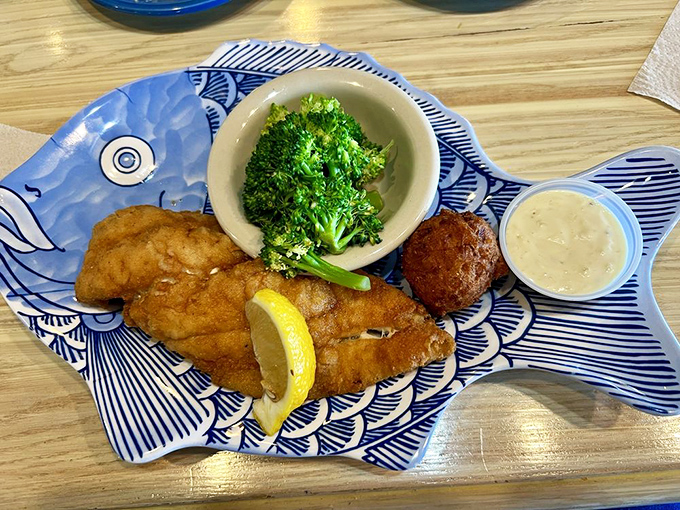 Golden-fried fish that flakes at the mere suggestion of a fork, served with vibrant broccoli and a hush puppy that deserves its own fan club.