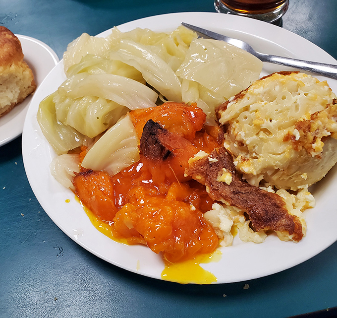 This plate tells the Southern story better than any novel – cabbage cooked with love, candied yams glowing like sunset, and mac and cheese that could make a cardiologist weep.