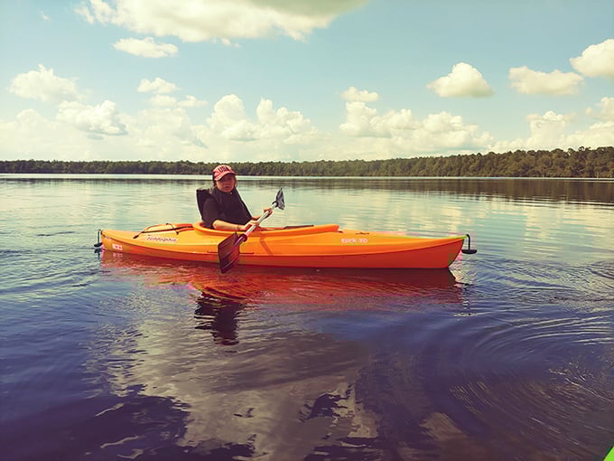 Nothing says "I'm living my best life" like paddling a bright orange kayak across tea-colored waters. This is social media gold without the crowds. 