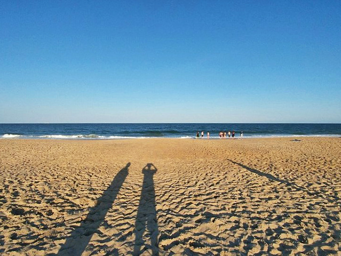 Beach shadows lengthen as families gather to create memories that outlast footprints in the sand.