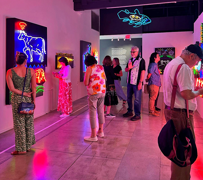 Visitors bask in the multicolored glow of neon artworks, their faces illuminated like moviegoers watching the best film they've never heard of.