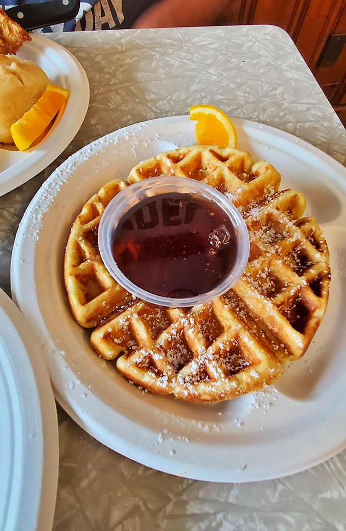 Golden waffles dusted with powdered sugar and served with pure maple syrup &ndash; breakfast bliss in its simplest form.