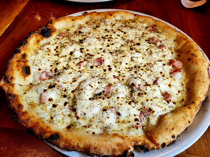 This white pizza with its perfectly charred crust and delicate toppings isn't just food &ndash; it's edible architecture with a PhD in deliciousness.