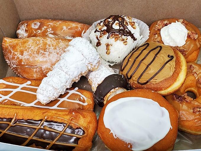 A box of donuts so glorious it should come with a warning label. That chocolate-topped beauty in the center is the Brad Pitt of pastries—impossible to ignore.