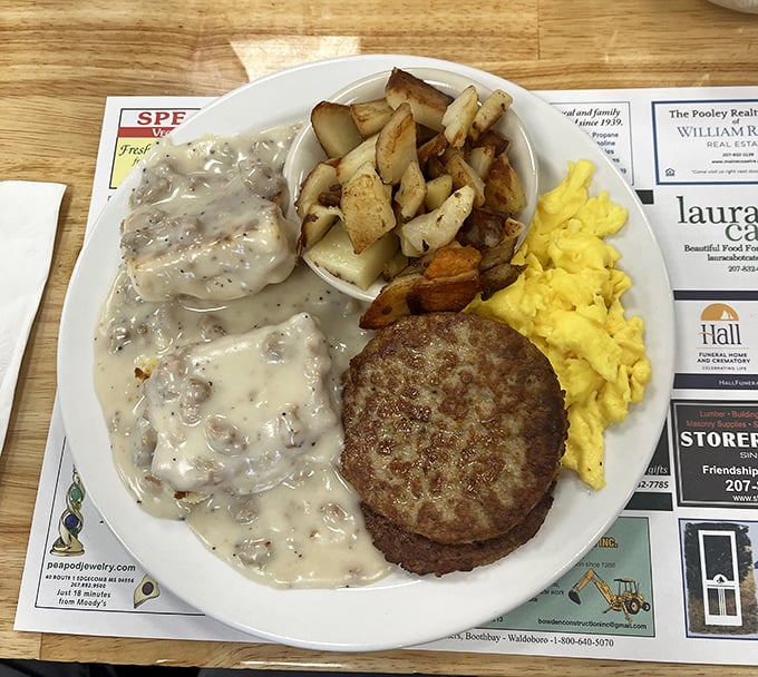 Biscuits and gravy done right: fluffy buttermilk biscuits drowning in peppered sausage gravy alongside perfectly seasoned home fries and scrambled eggs.