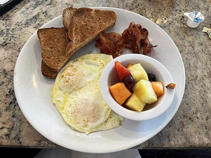 Simplicity done right: perfectly cooked eggs, crispy bacon, and fresh fruit. Breakfast's greatest hits on a single plate, no autotune required.