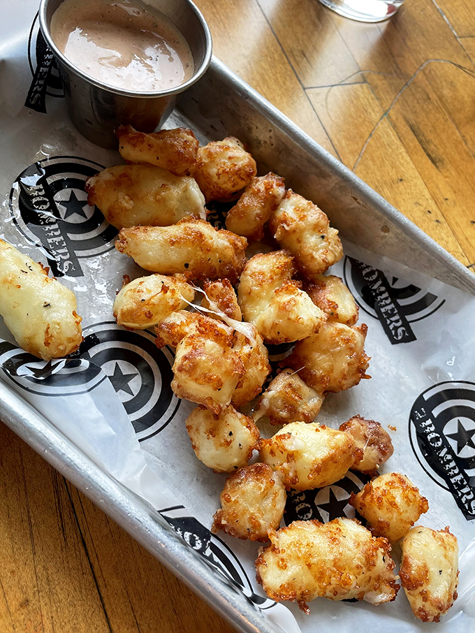 Wisconsin's golden treasures! These cheese curds achieve the impossible trifecta: crispy exterior, molten interior, and enough stretchy goodness to make a yoga instructor jealous.