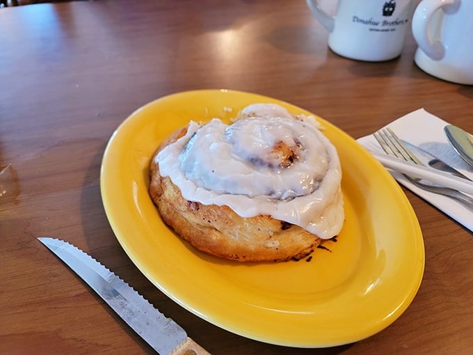This cinnamon bun isn't just breakfast&mdash;it's therapy on a sunny yellow plate, with frosting so generous it's practically wearing a winter coat.
