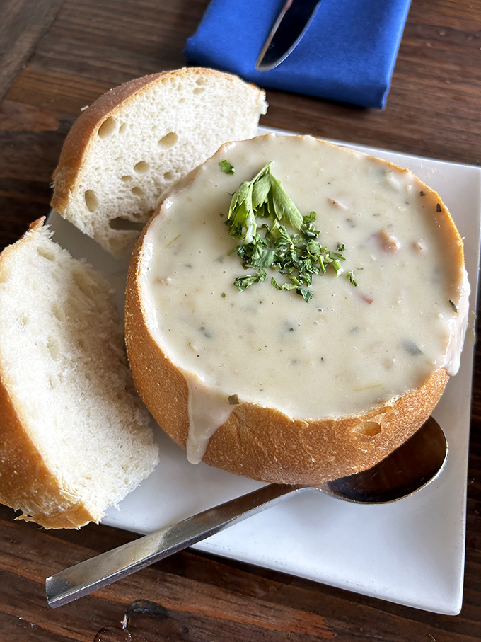 This isn't just clam chowder; it's a creamy revelation in a sourdough fortress. The fresh herbs on top aren't garnish&mdash;they're the crown jewels.