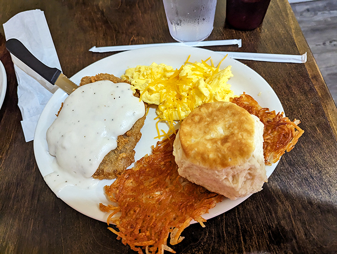 Country fried steak smothered in creamy gravy, golden hash browns, and a biscuit that could make a Southern grandma nod in approval. Breakfast doesn't get more serious than this.d steak