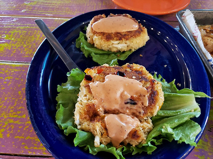 Golden-brown crab cakes perched on crisp lettuce&mdash;where sweet lump crabmeat meets a perfectly seasoned crust in seafood harmony.