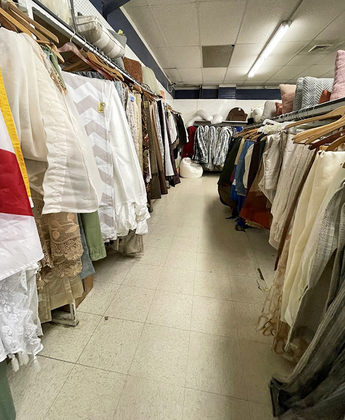 The clothing aisles stretch into the distance like fabric-lined canyons. Each hanger holds someone's past and someone else's future fashion statement.