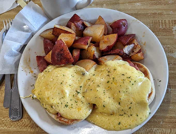 These eggs Benedict aren't just breakfast&mdash;they're a masterclass in hollandaise architecture, perfectly cascading over English muffins alongside home fries that mean business.