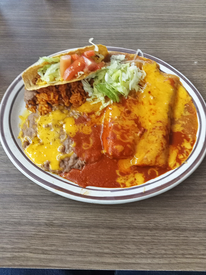 Two enchiladas swimming in chile with rice, beans, and a taco makes you wonder why anyone bothers eating breakfast any other way.