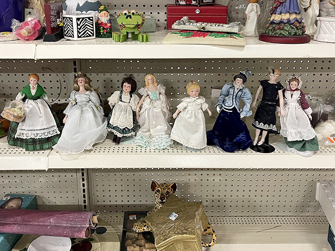 A porcelain parliament of dolls stands at attention, their painted eyes following you with the silent question: "Will you take me home today?"