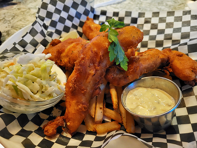 Golden-battered fish that shatters at first bite, nestled atop hand-cut fries. Coleslaw and tartar sauce complete this symphony of crunch and cream.