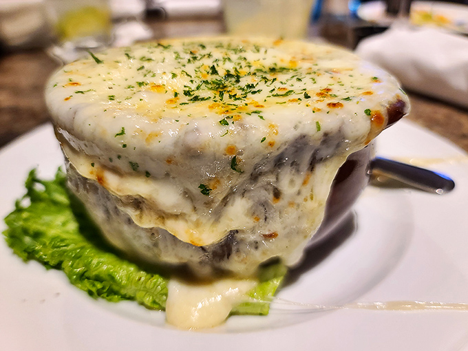 The French onion soup arrives like a cheese volcano that erupted over a savory beef broth island. Stretchy, gooey, and worth every stringy bite.
