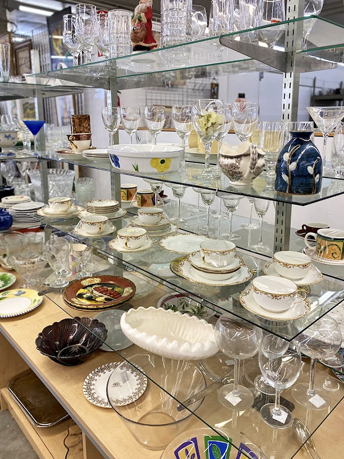 Crystal stemware and delicate china await new homes, proving that champagne taste and beer budget can happily coexist under fluorescent lighting.