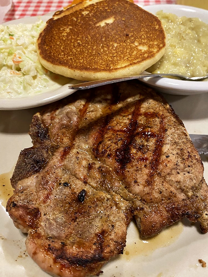 This grilled pork chop doesn't just sit on the plate&mdash;it commands attention with perfect grill marks and sides that know their supporting role.