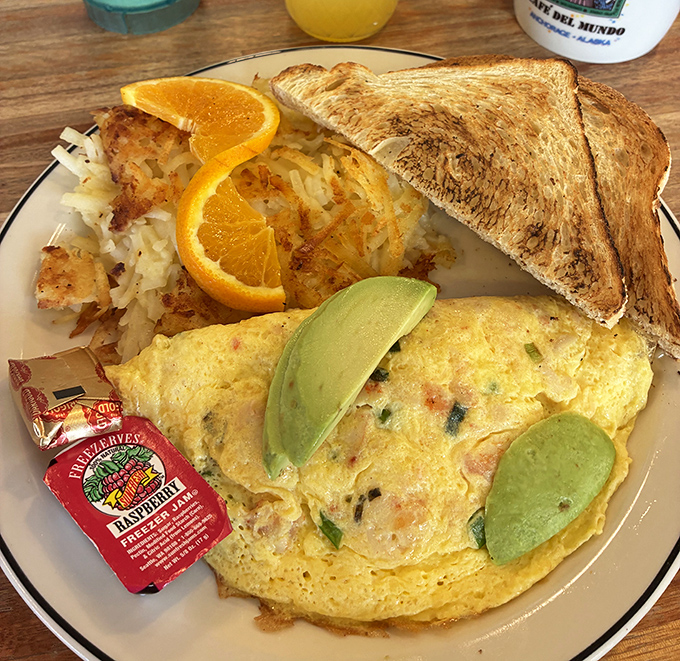 This isn't just an omelet&mdash;it's edible sunshine. Perfectly folded eggs with fresh avocado slices and crispy hash browns that could convert a breakfast skeptic.