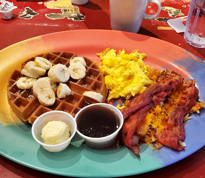 Breakfast harmony achieved: golden waffle, fluffy scrambled eggs, and bacon cooked to that perfect crisp-yet-chewy sweet spot that breakfast dreams are made of.