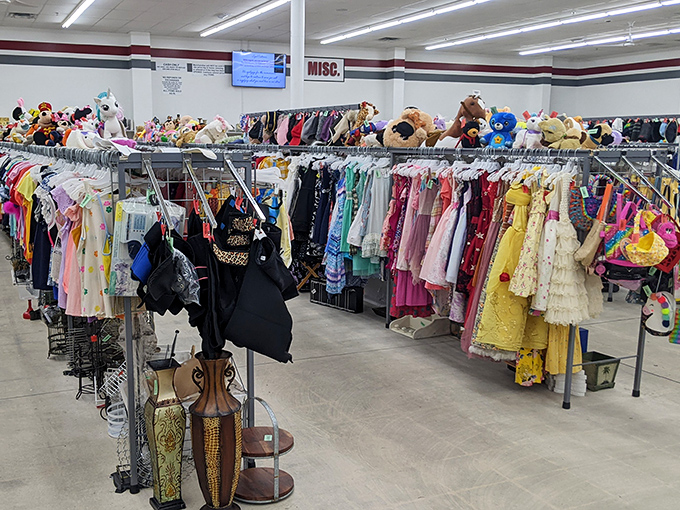 A rainbow explosion of children's formal wear hangs above plush toys, as if tiny royalty might arrive any minute for their coronation ball.