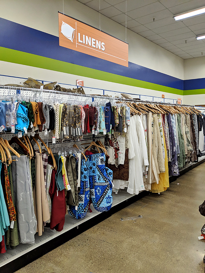 The linens section—where yesterday's tablecloths become tomorrow's craft projects, and vintage sheets await their second act.