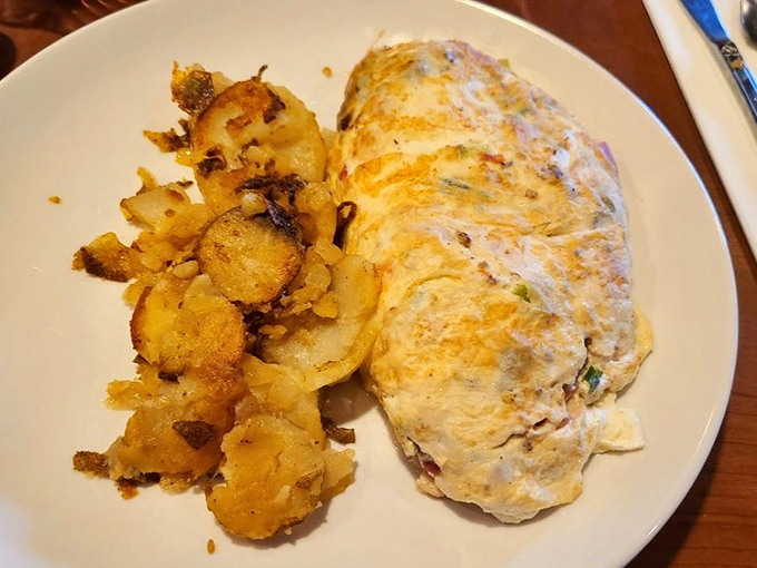 Behold the perfect omelet&mdash;fluffy on the outside, packed with goodness inside. Paired with those golden home fries, it's breakfast nirvana on a plate.