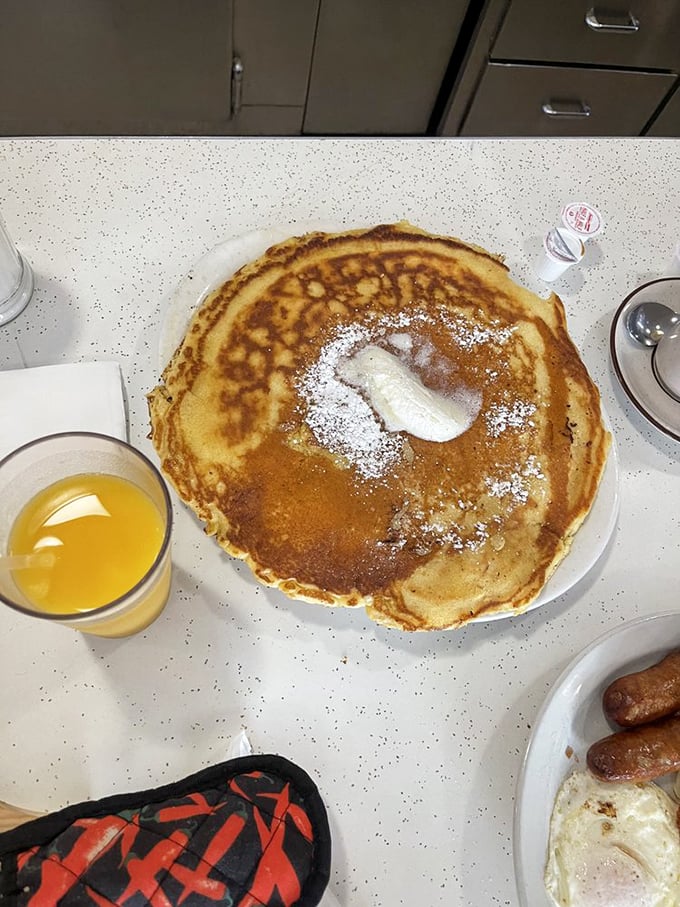 The pancake that launched a thousand return visits. Golden, plate-sized perfection with a melting pat of butter and a dusting of powdered sugar.
