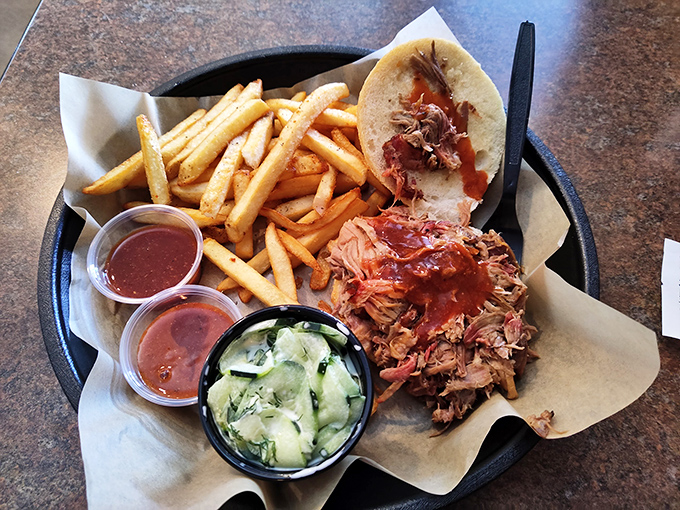 Pulled pork paradise on a platter, with enough sauce options to make your taste buds dance.