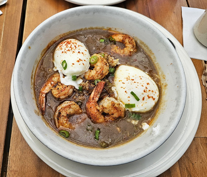Behold the legendary shrimp and grits—plump crustaceans swimming in savory goodness, topped with poached eggs that break open like sunrise over the Atlantic.