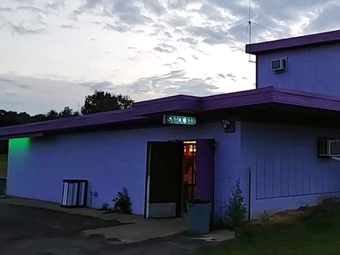 The "SNACK BAR" sign glows like a beacon of hope for hungry moviegoers who've realized dinner in the car wasn't enough.
