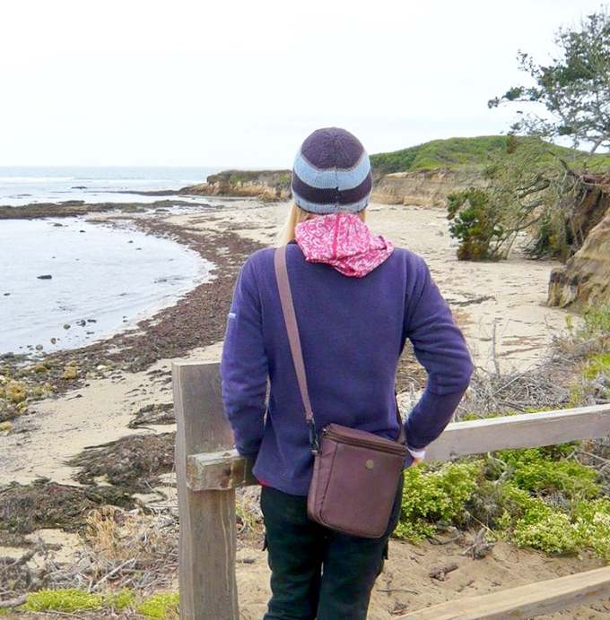 Bundled against the coastal breeze, a visitor takes in the rugged shoreline views that Spanish explorers first glimpsed over four centuries ago.