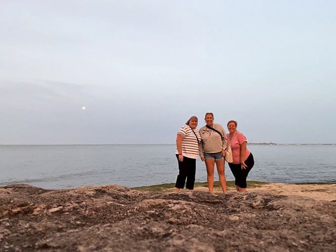 Visitors capturing that "we were here" moment on Marblehead's rocky shore. Some memories deserve more than just mental snapshots.