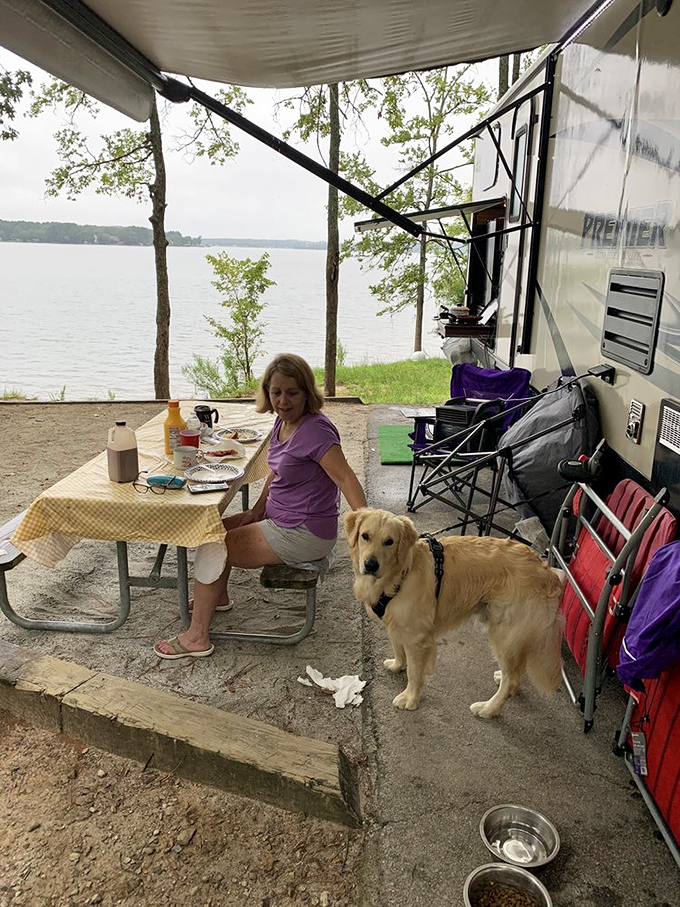 Campsite bliss. Nothing says "I'm actually relaxing" like a picnic table breakfast with your four-legged friend and the lake as your dining room.