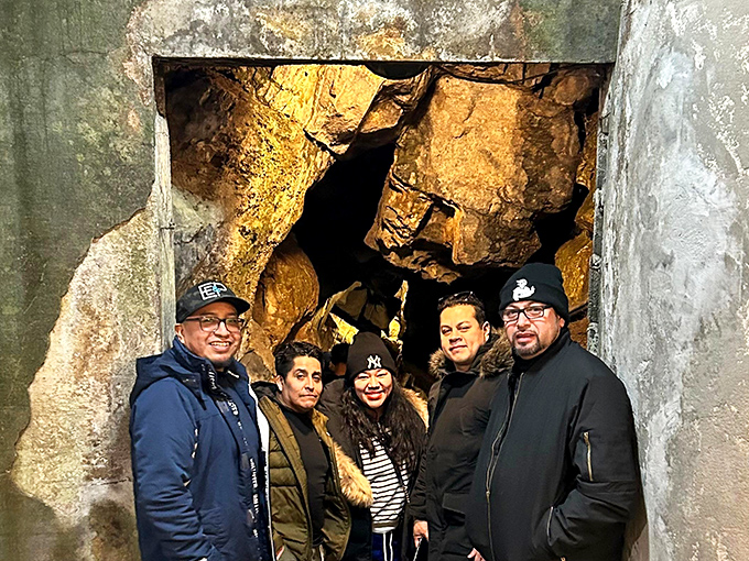Visitors gather at the cavern entrance, bundled against the surface chill before experiencing the cave's constant 52-degree microclimate.