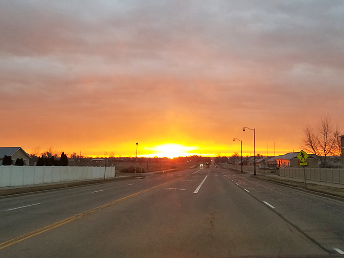 Golden hour paints these quiet streets where gas prices glow as warmly as the setting sun.
