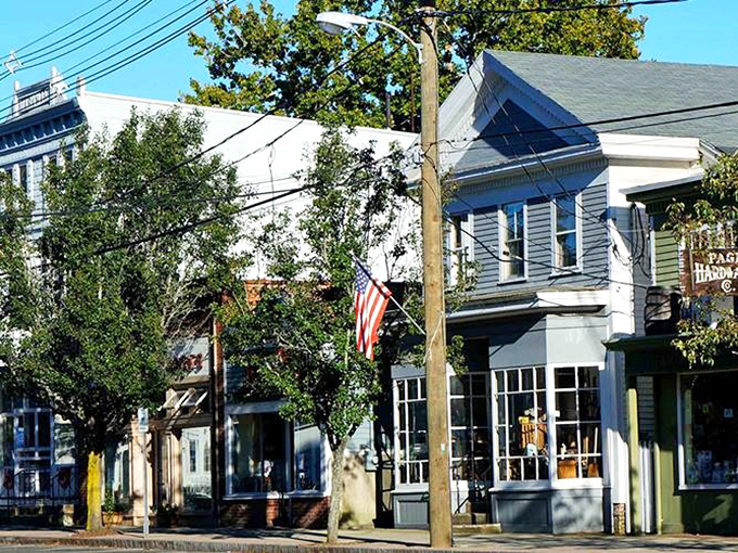 Charming storefronts line up like good neighbors, their colorful facades and American flag adding personality to this historic main street.
