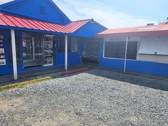 Blue as the ocean, red as cooked lobster! This vibrant seafood shack screams "fresh catch" louder than a fisherman who just found the perfect spot.
